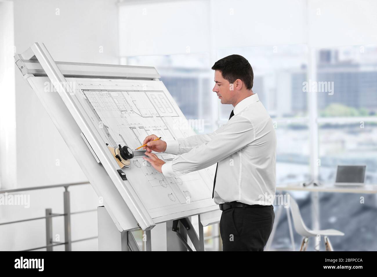 Young creative male engineer making project on drawing board Stock ...