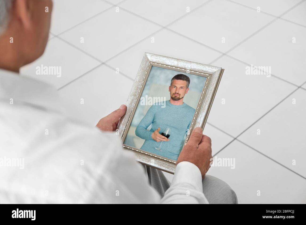 Male hands holding photo frame with picture of man. Happy memories ...