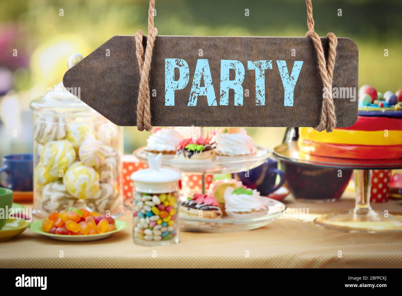 Word PARTY on wooden signboard against blurred festive table background ...