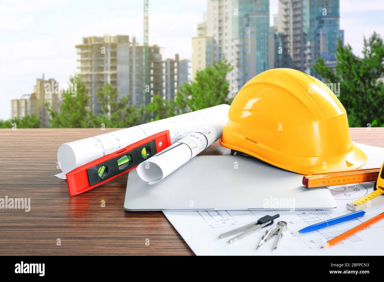 Construction blueprints with tools and helmet on building construction ...