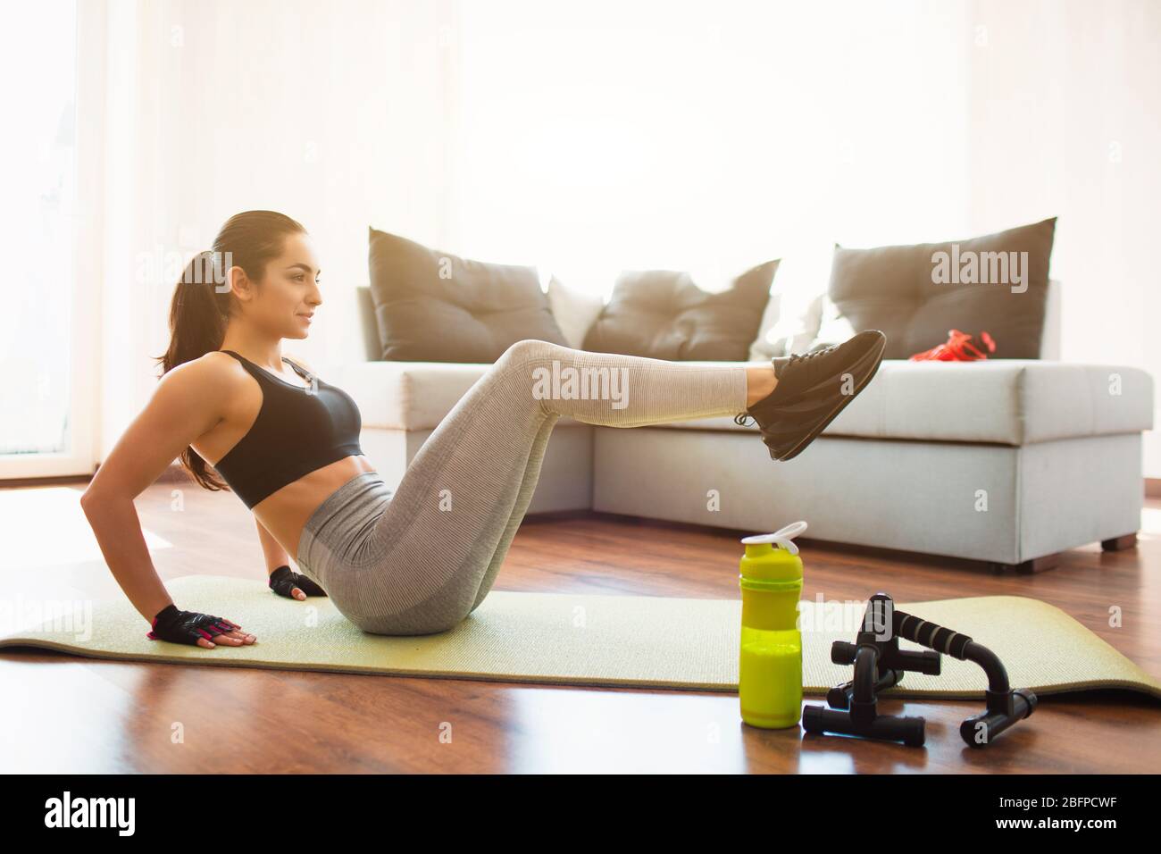 Young woman doing sport workout in room during quarantine. Lean on ...