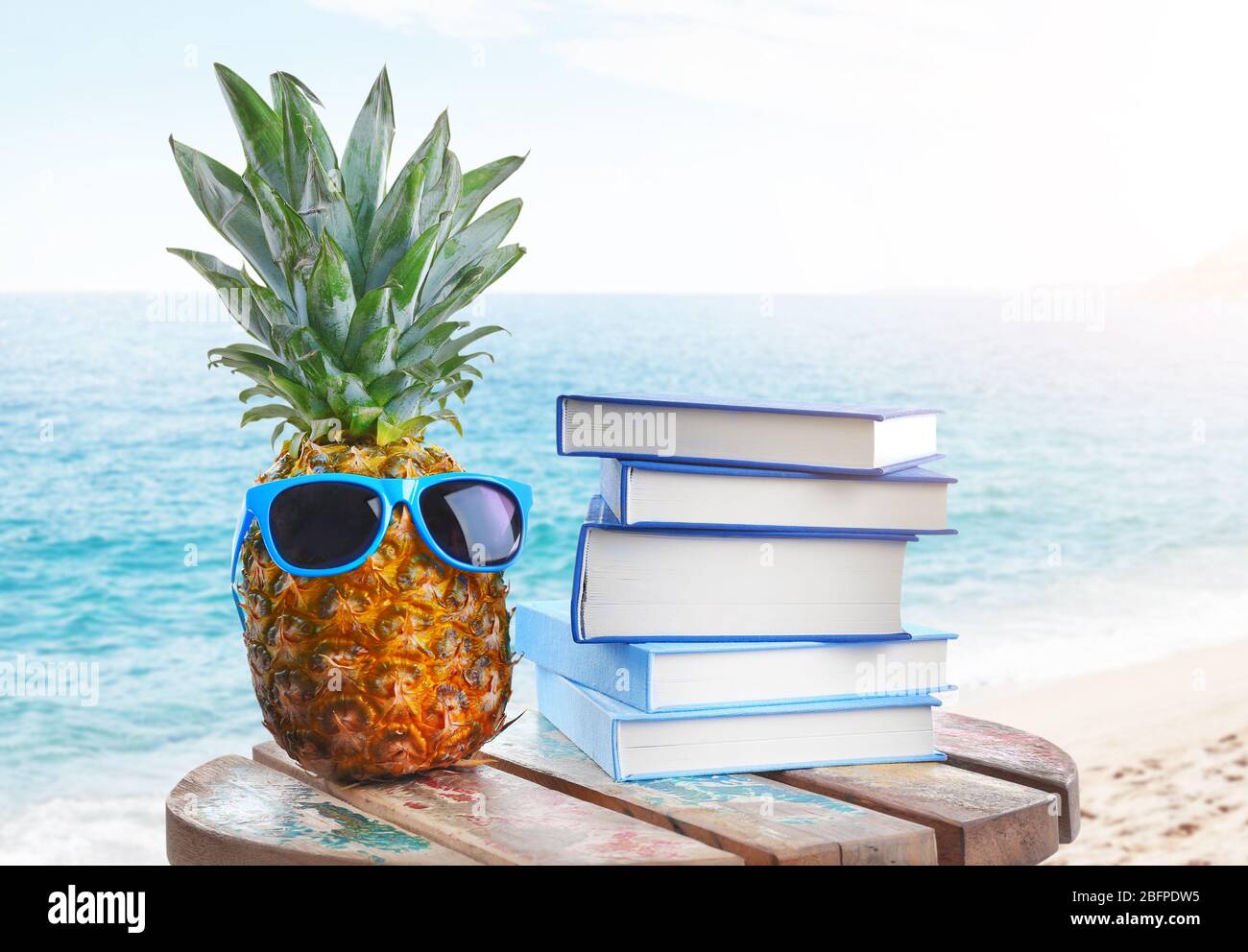 Reading during summer vacation. Books, pineapple and sunglasses on ...
