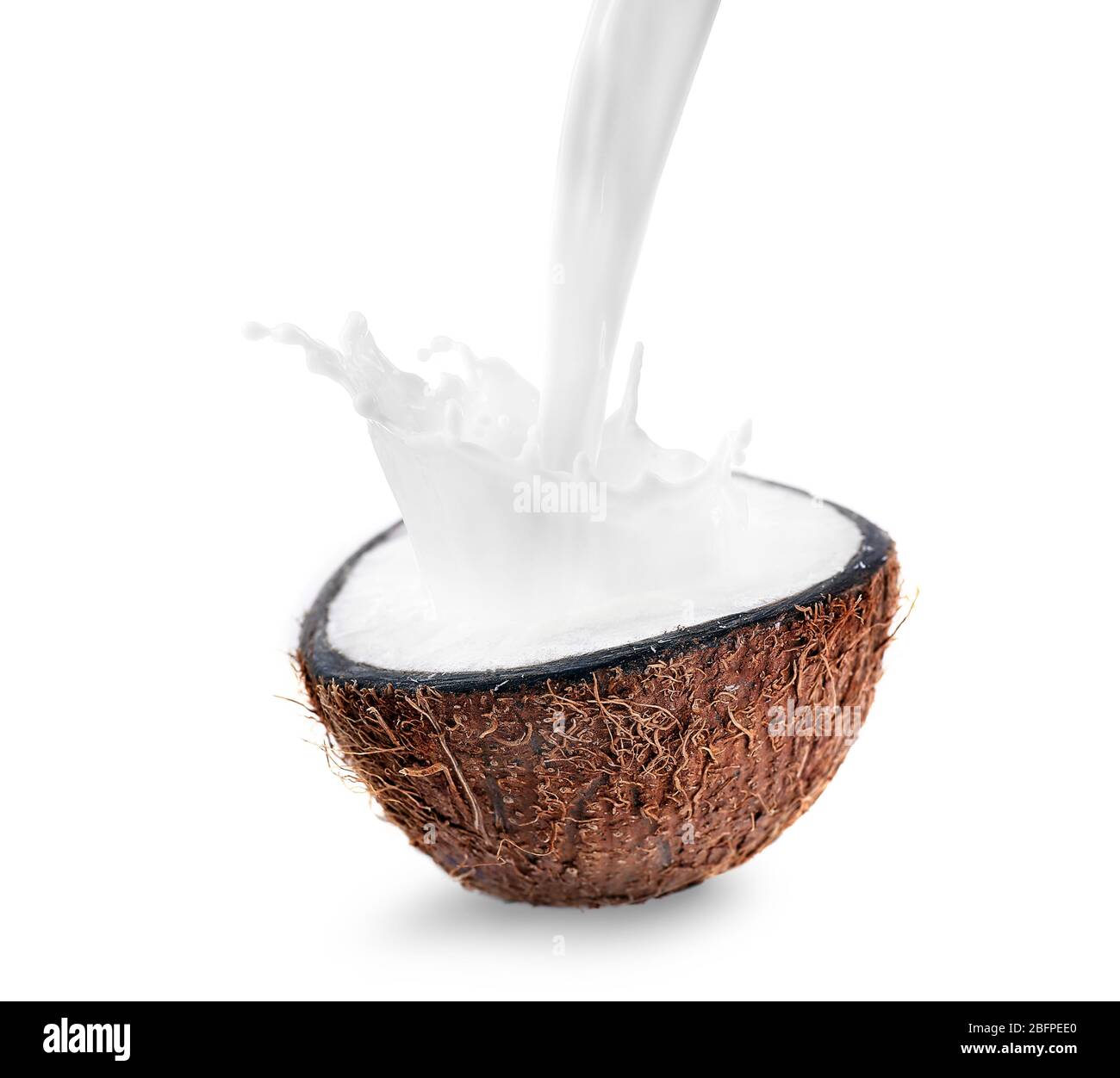 Pouring coconut milk into shell on white background Stock Photo - Alamy