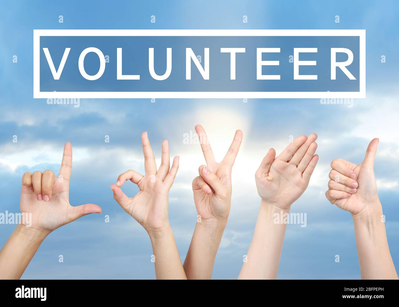Volunteer concept. People raising hands and text on sky background ...