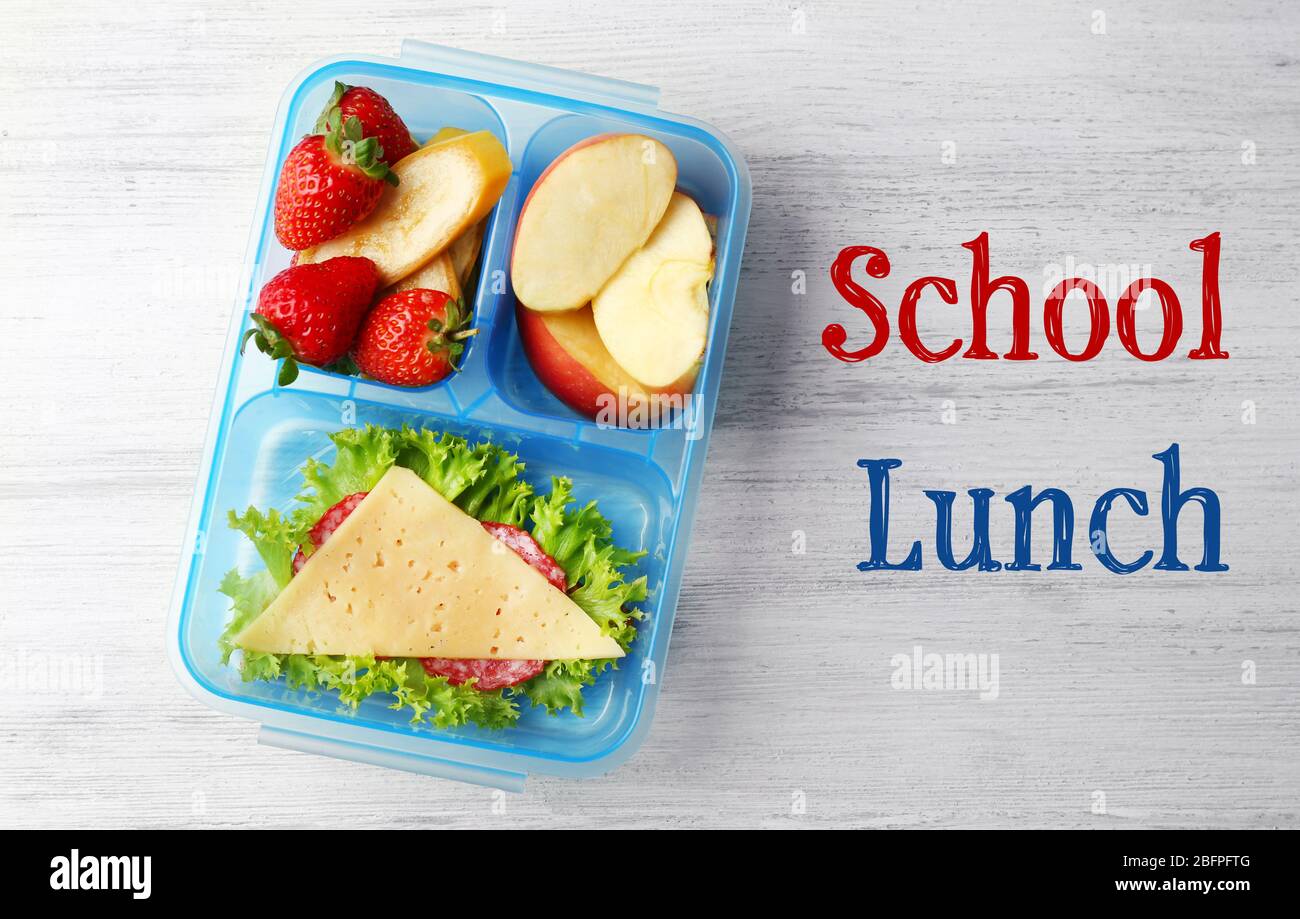 Concept of school lunch. Lunchbox and food on wooden background Stock ...