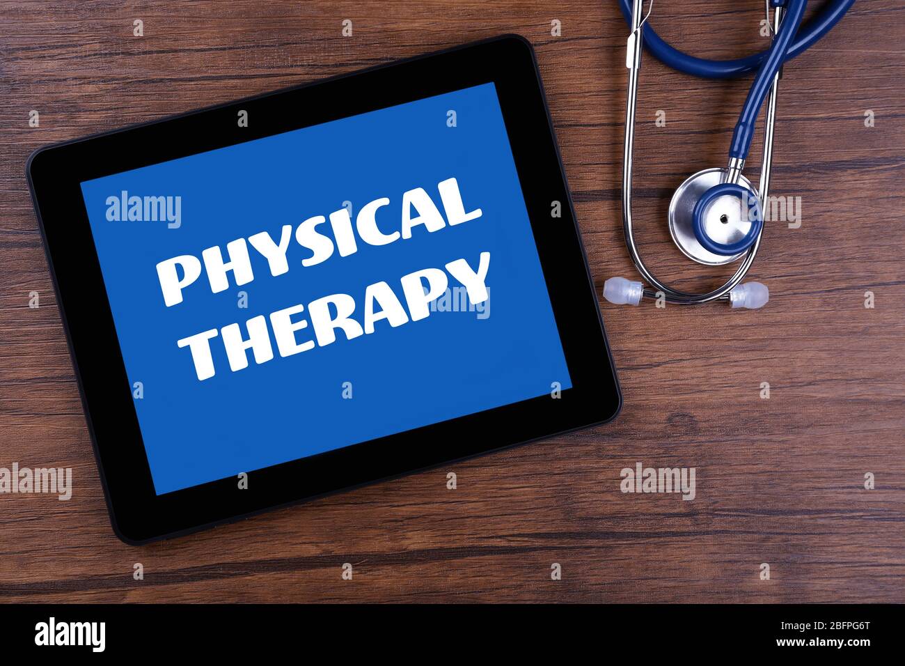 Rehabilitation concept. Tablet and stethoscope on wooden background ...