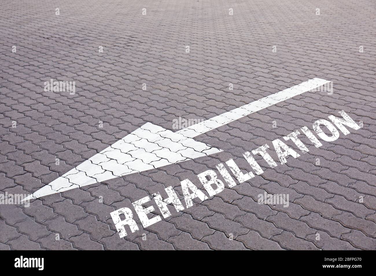 Recovery concept. Arrow pointing way to REHABILITATION on pavement ...