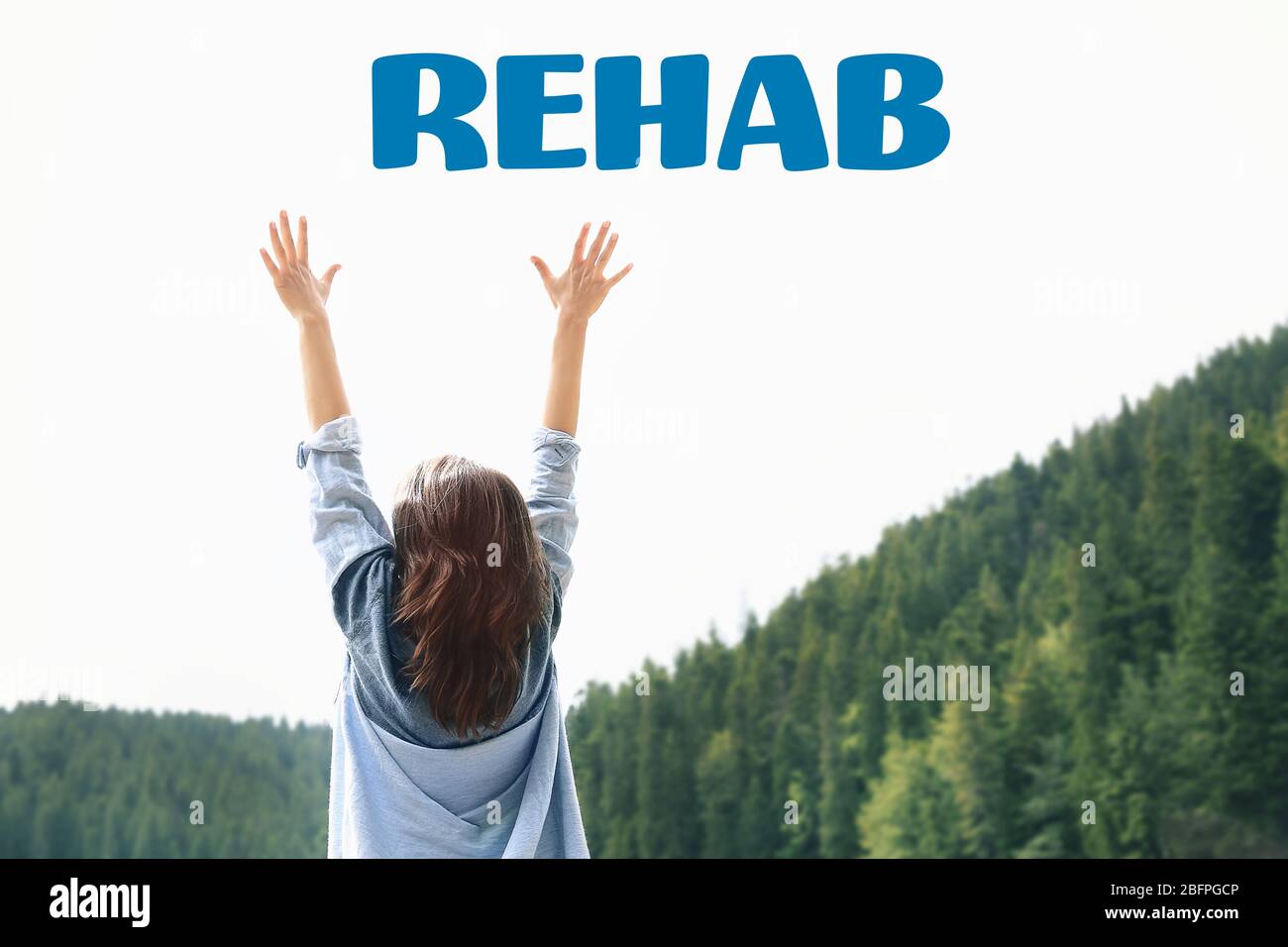 Recovery concept. Word REHAB and woman raising hands on landscape ...