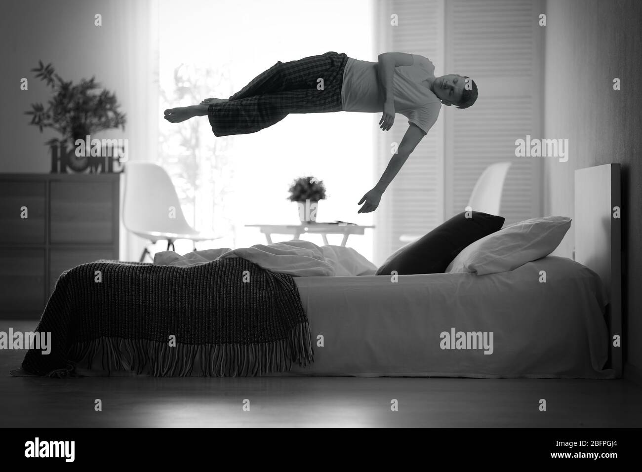 Sleep paralysis concept. Young man levitating over bed Stock Photo - Alamy