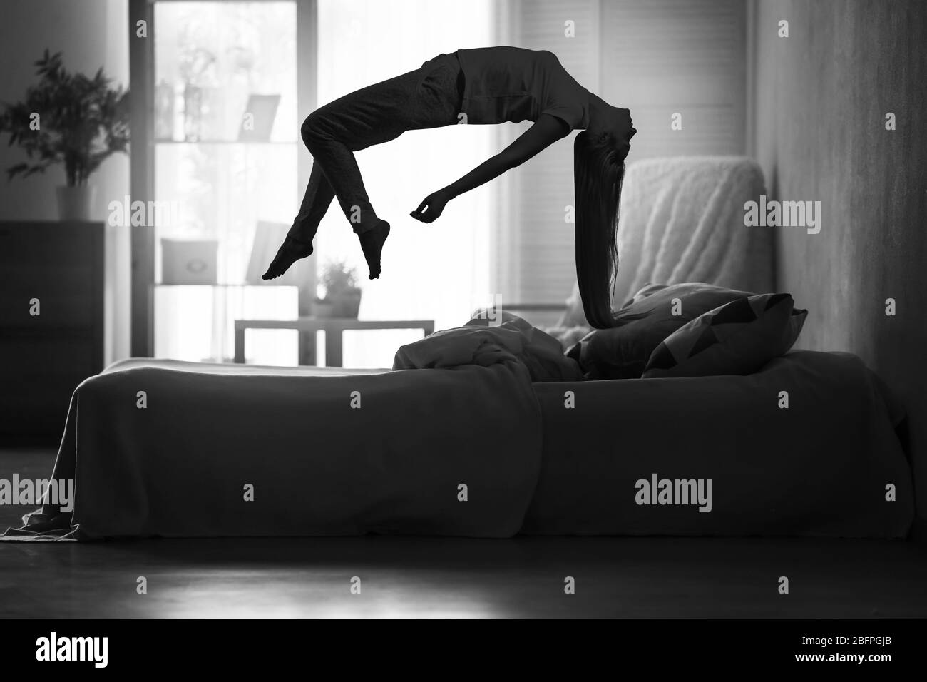 Sleep paralysis concept. Young woman levitating over bed Stock Photo ...