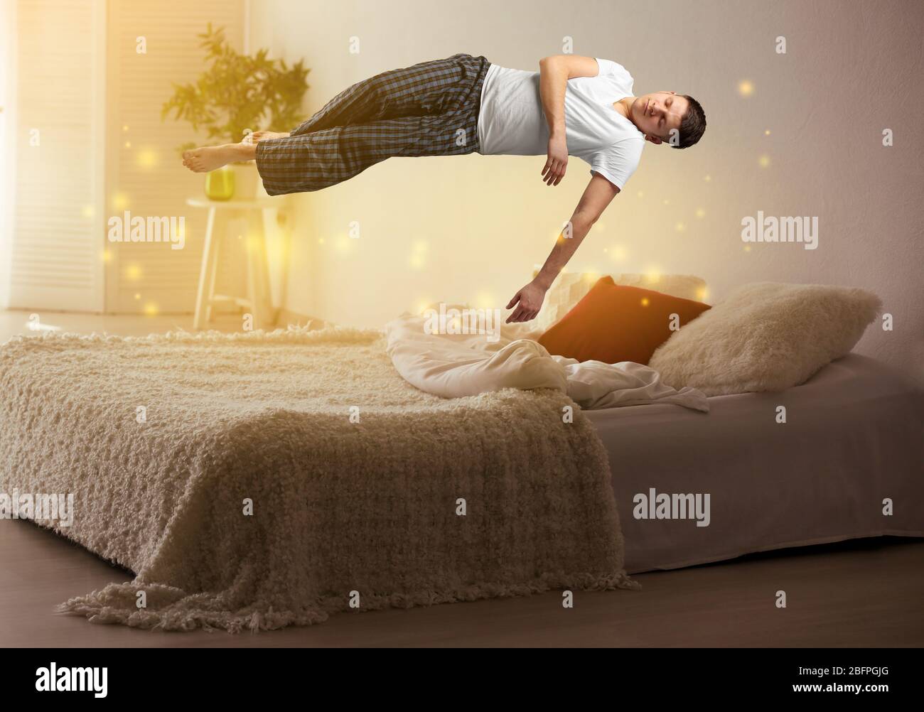 Sleep paralysis concept. Young man levitating over bed Stock Photo - Alamy