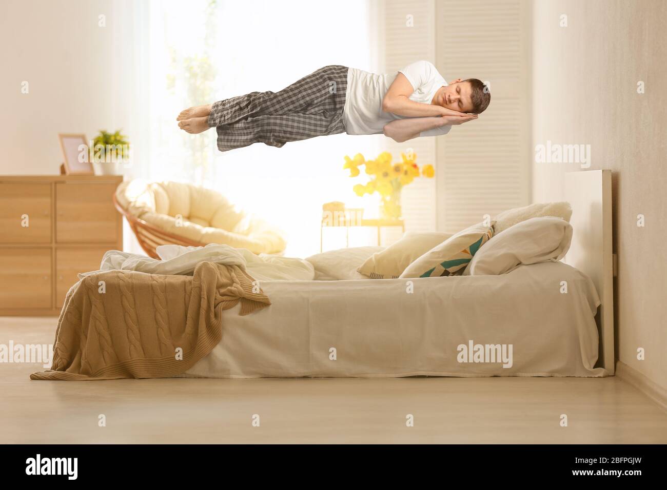 Sleep paralysis concept. Young man levitating over bed Stock Photo - Alamy