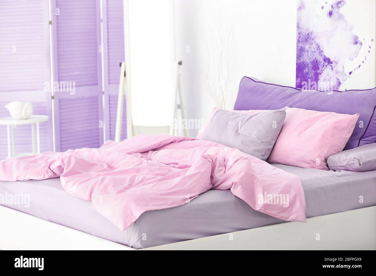 Lilac color accent in modern interior. Comfortable bed in light room ...