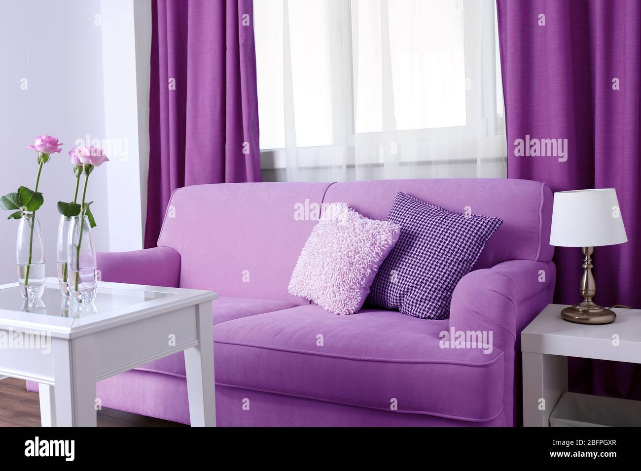 Lilac color accent in modern interior. Comfortable couch and table with ...