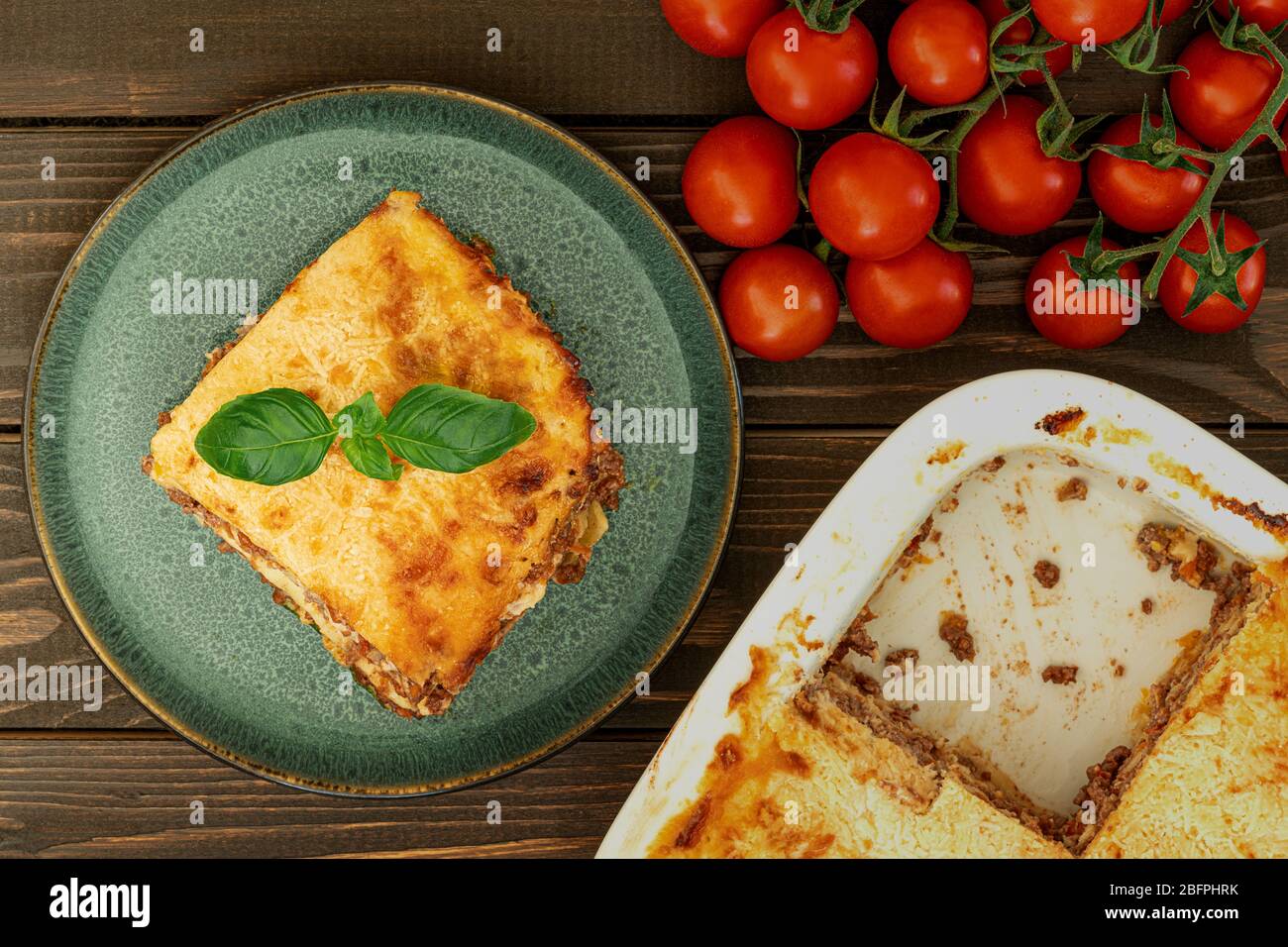Classic Italian lasagna piece at plate on wooden table from above ...