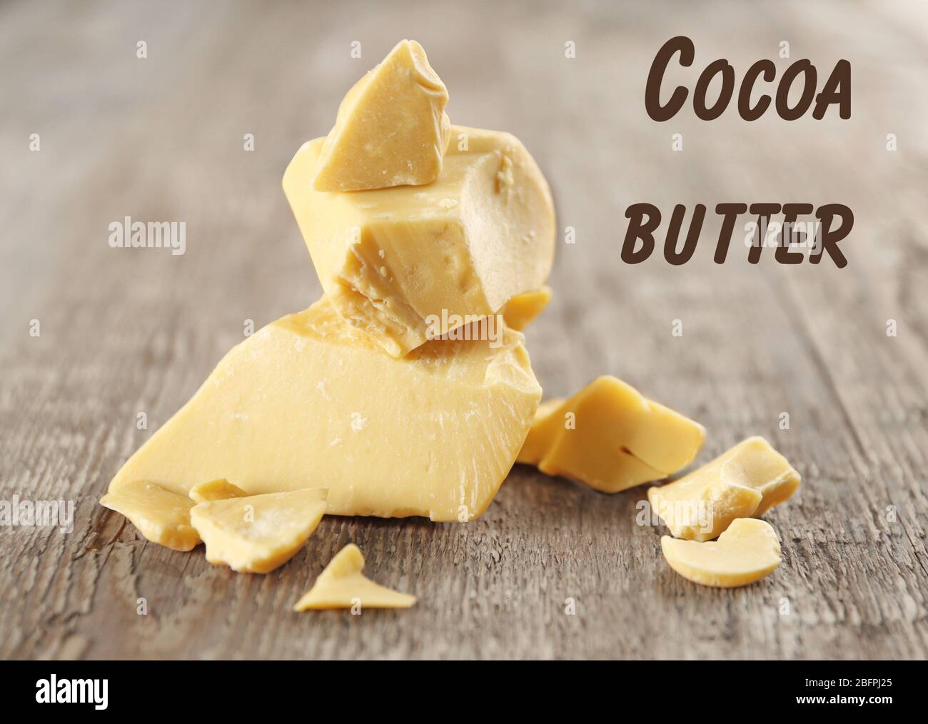 Pieces of cocoa butter with text on wooden background Stock Photo - Alamy