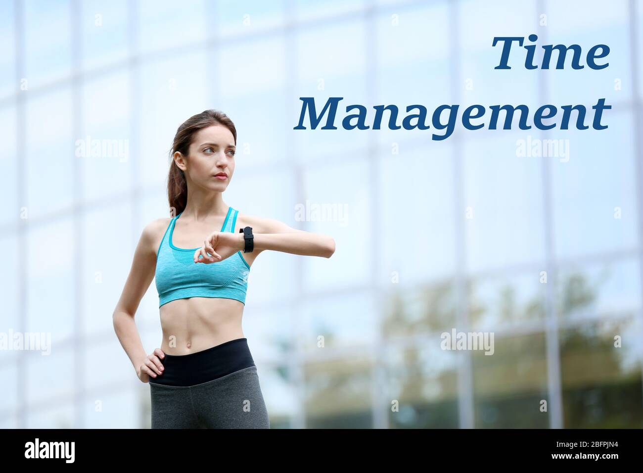 Time management concept. Sporty young woman with wrist watch outdoor ...