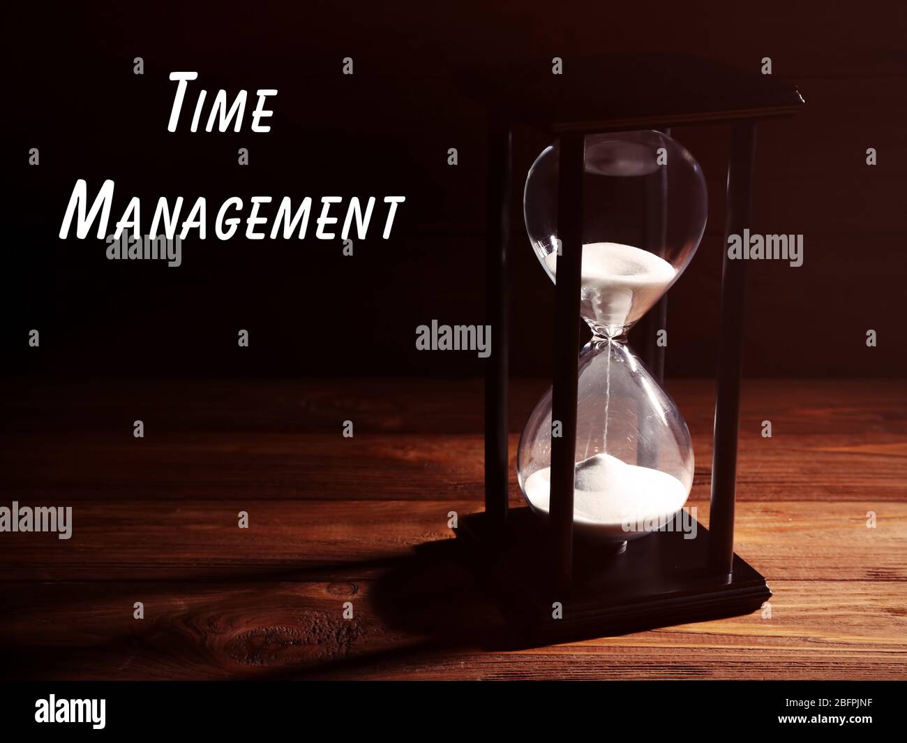 Time management concept. Hourglass on dark background Stock Photo - Alamy