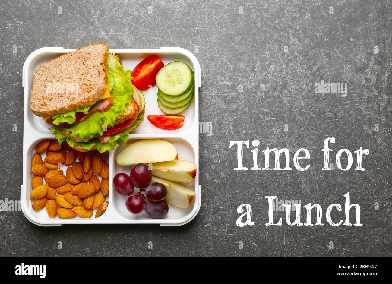 Text TIME FOR A LUNCH and tray with food on gray background Stock Photo ...