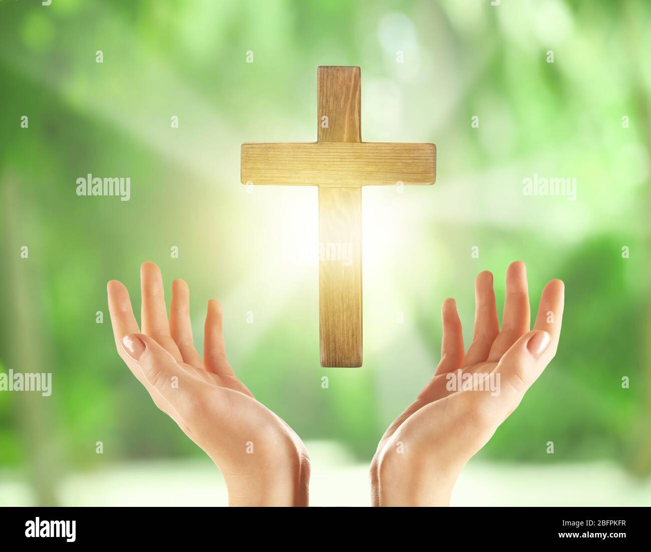 Freedom of religion concept. Female hands with wooden cross on blurred ...