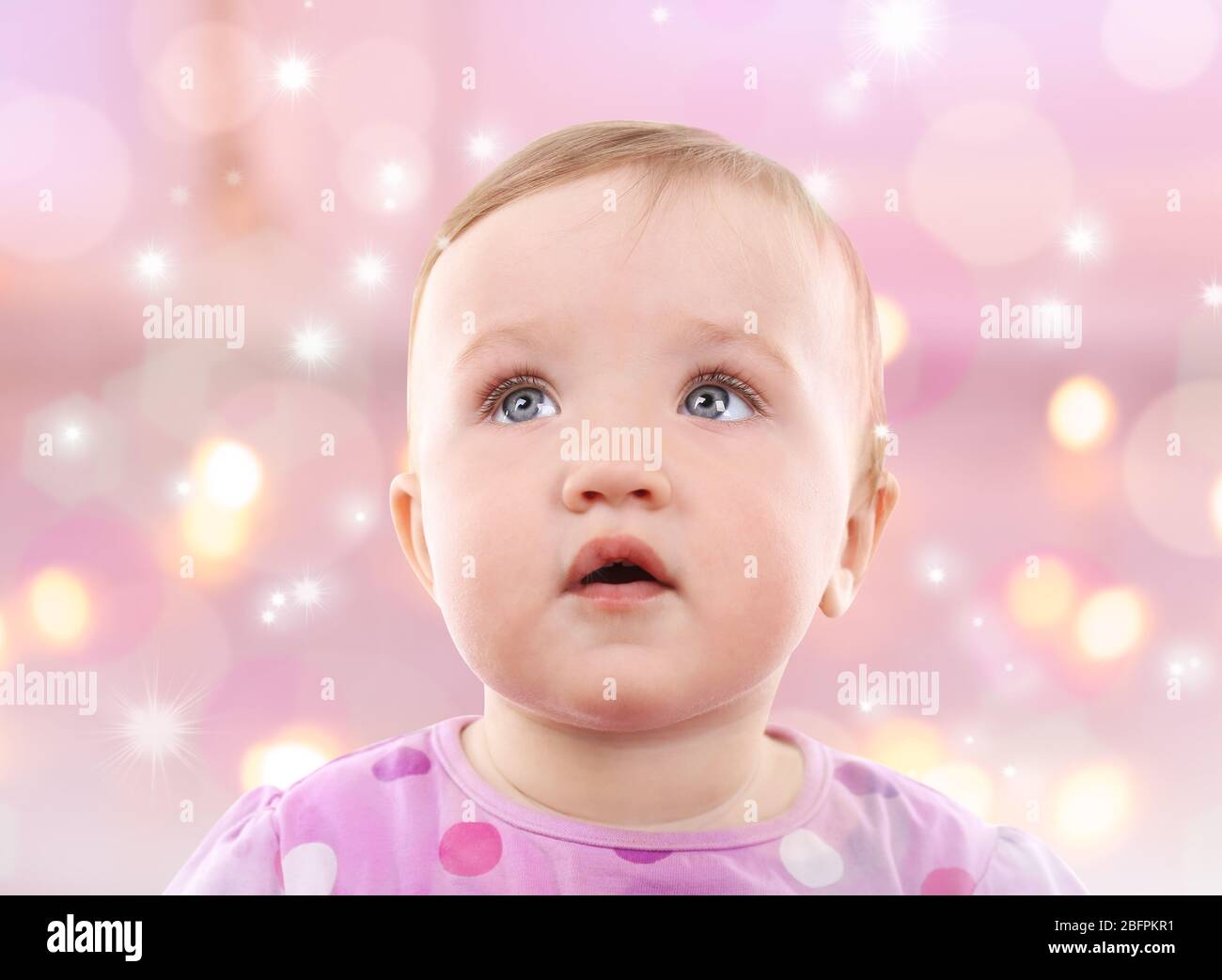 Cute baby girl on blurred lights background. Holidays celebration ...