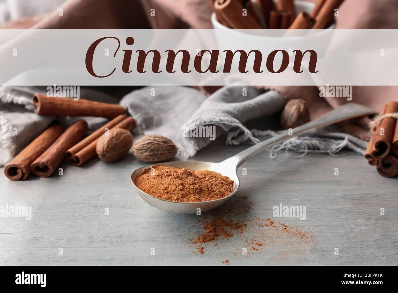 Spoon with powdered cinnamon on grey background Stock Photo - Alamy