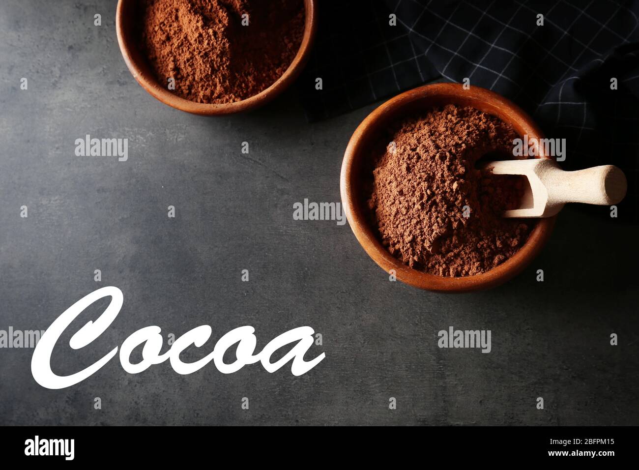 Bowl and scoop with cocoa powder on dark background Stock Photo - Alamy