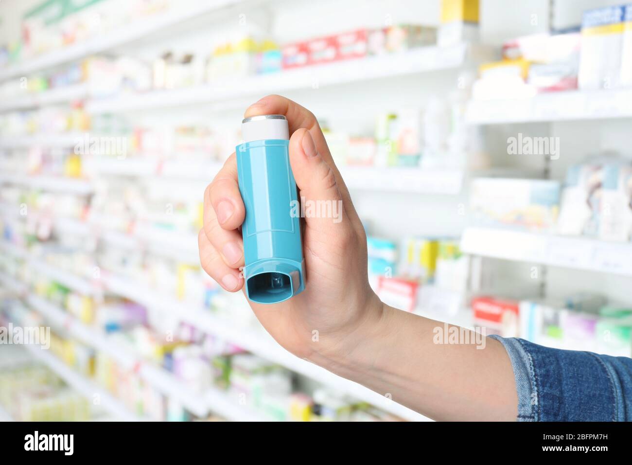 Concept of health care and asthma. Woman holding inhaler at pharmacy ...