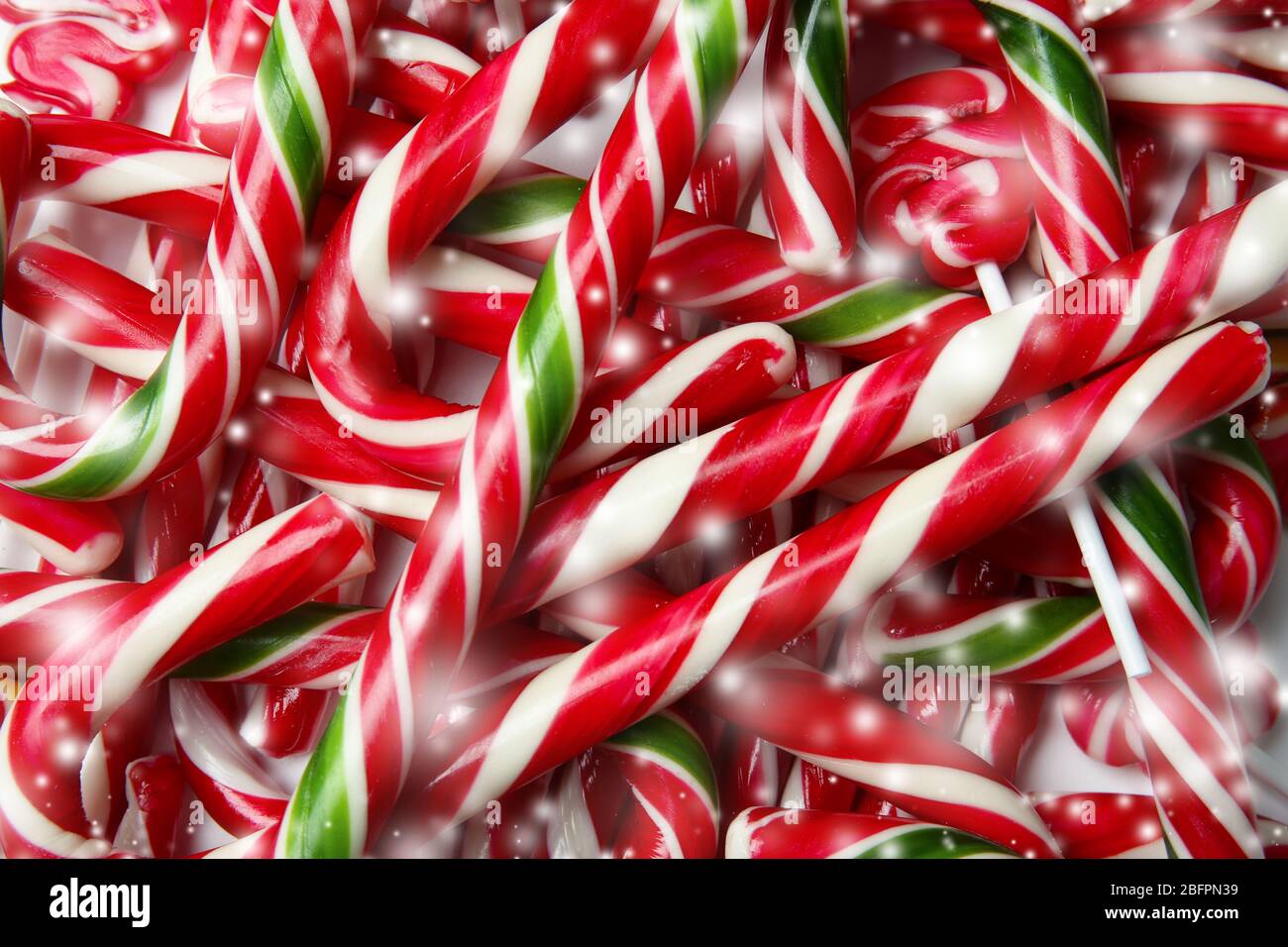 Christmas candy canes, closeup. Snow effect Stock Photo - Alamy