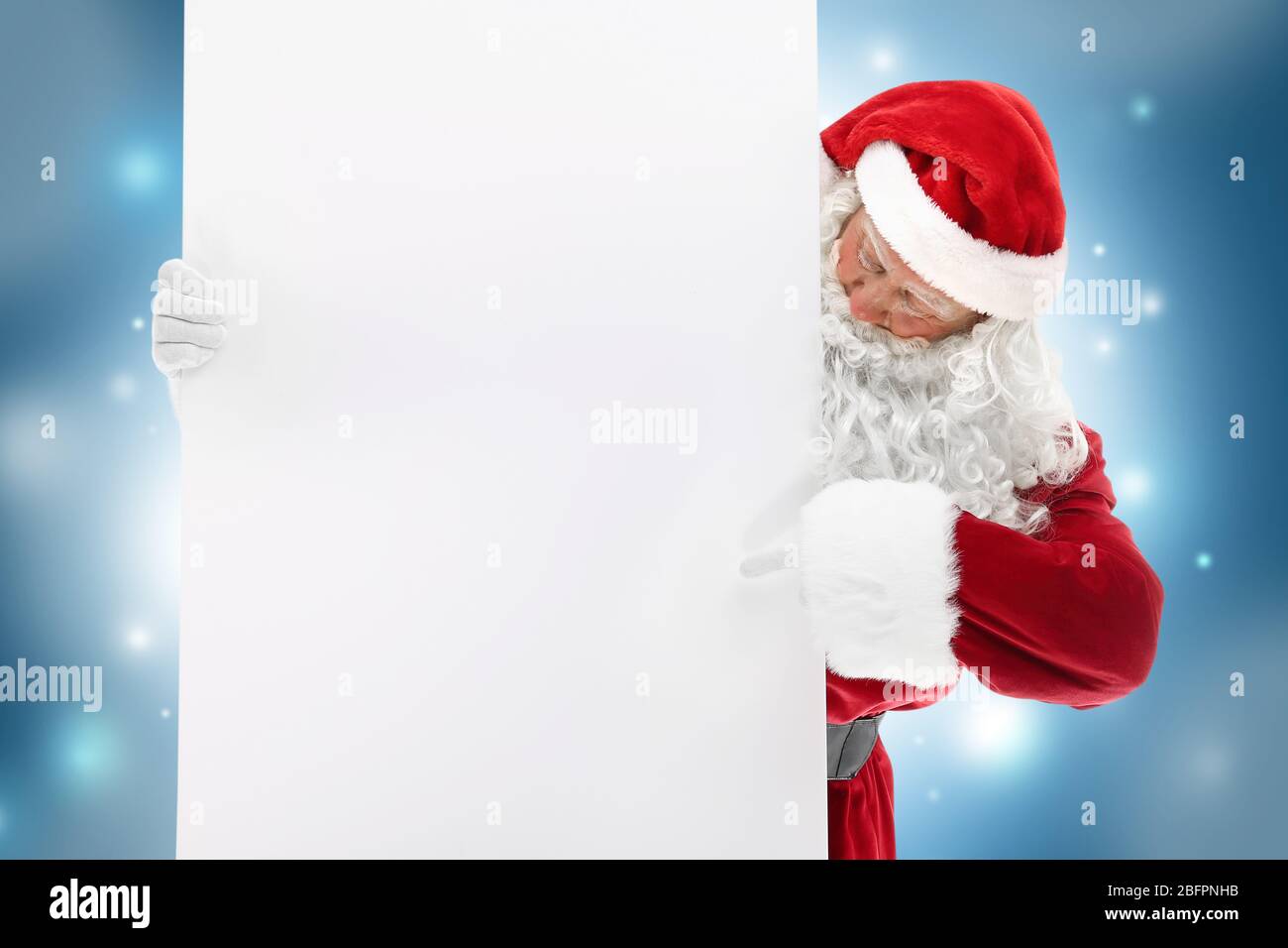 Santa Claus with blank poster on blurred lights background Stock Photo ...