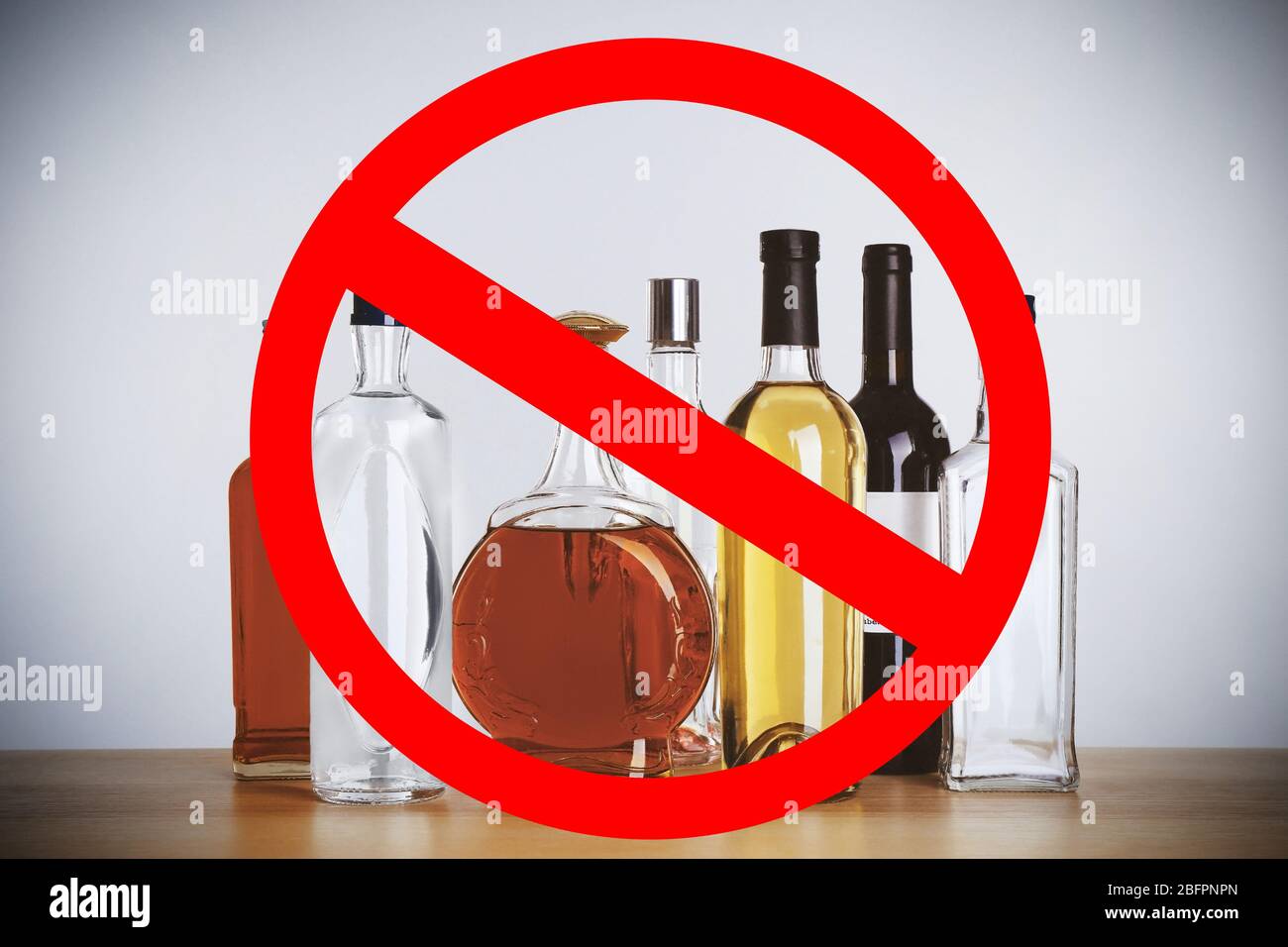 Different alcohol drinks in bottles with STOP sign on grey background ...