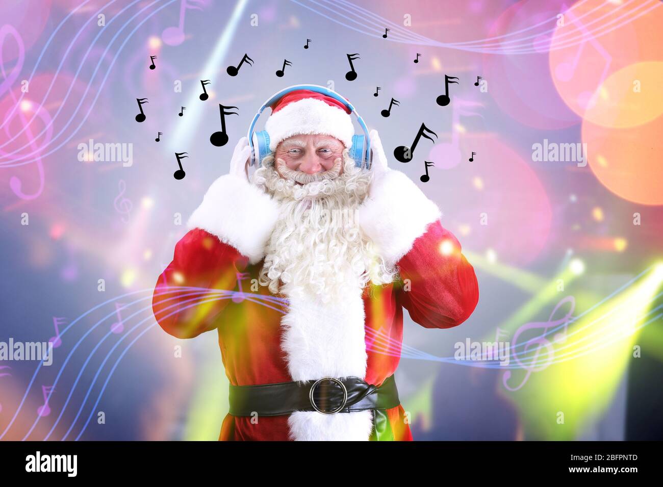 Santa Claus with headphones listening to music on blurred lights ...