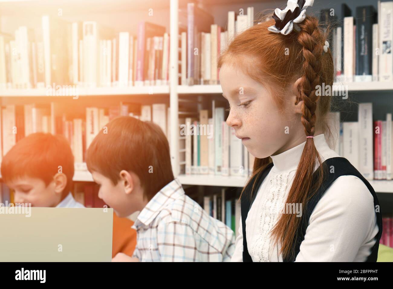 Little girl with classmates at school library Stock Photo - Alamy