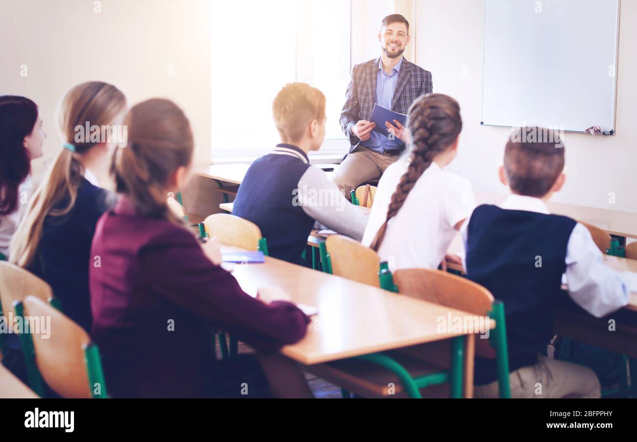 Children listening teacher in classroom at school Stock Photo - Alamy