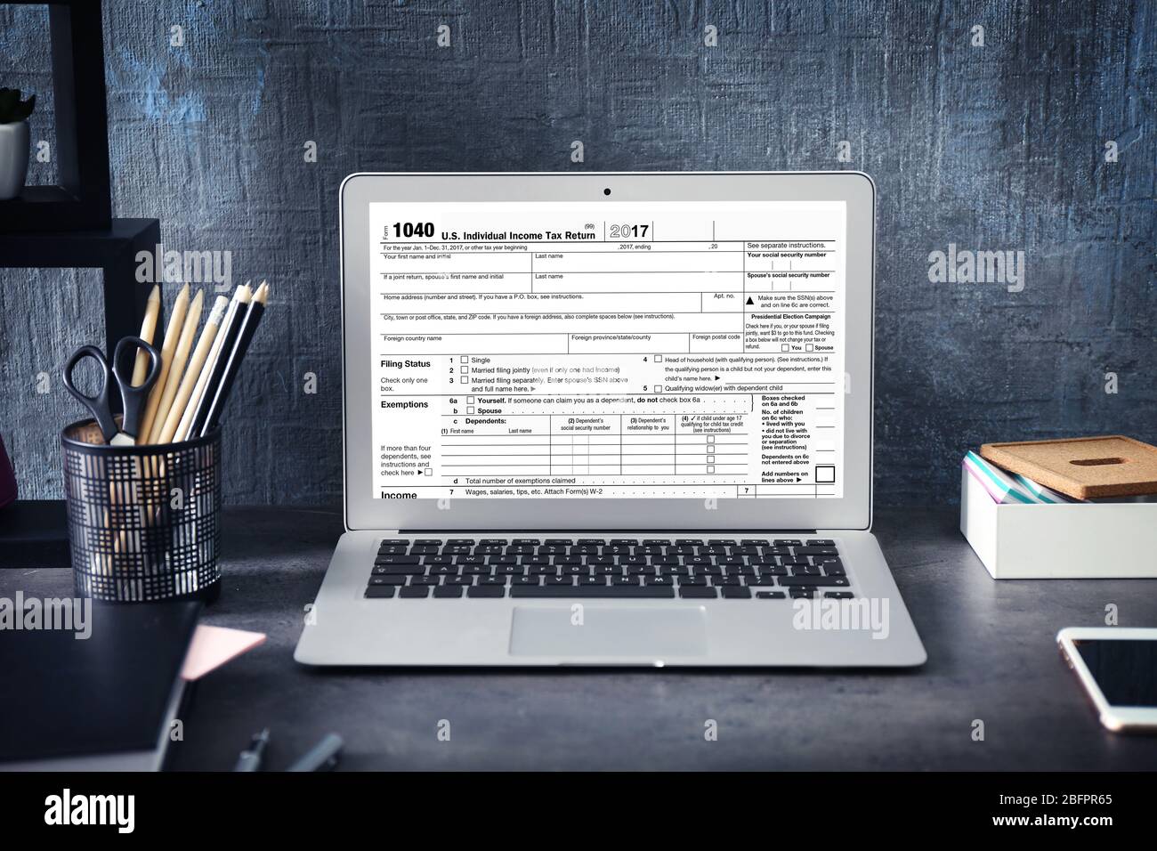 Workplace with office stationery. Laptop with individual income tax ...