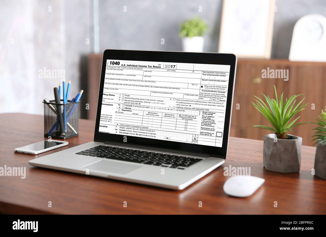 Workplace with office stationery. Laptop with individual income tax ...