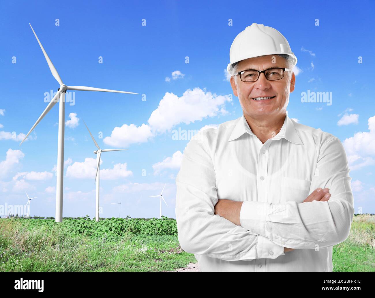 Senior engineer and wind turbines on background Stock Photo - Alamy