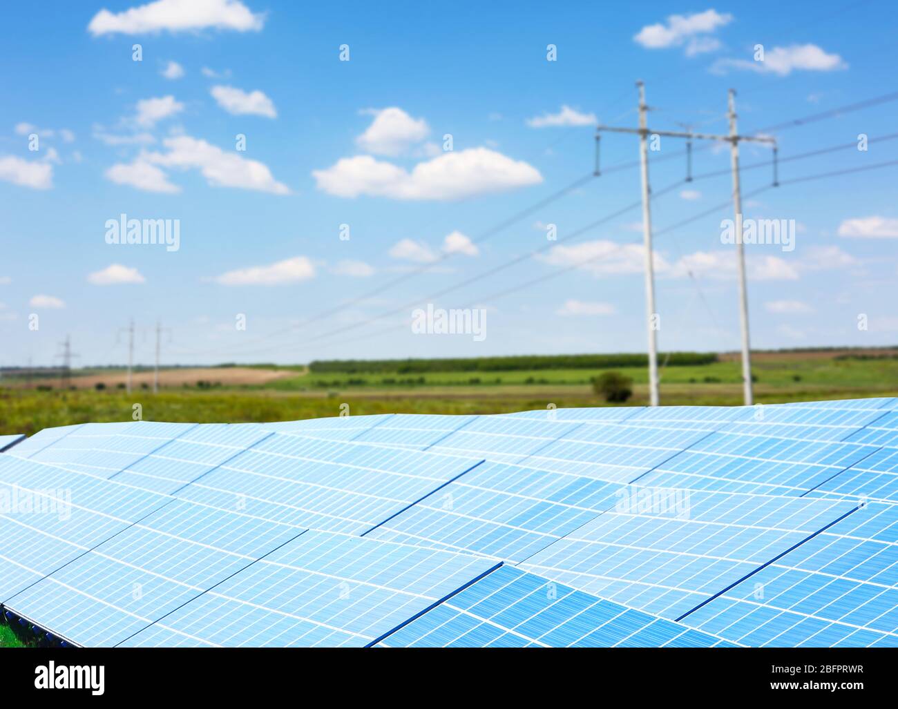 Solar panels and electrical transmission towers in field. Concept of ...