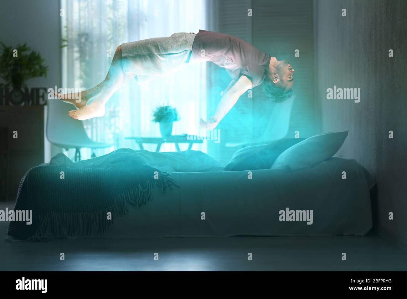 Sleep paralysis concept. Young man levitating over bed Stock Photo - Alamy