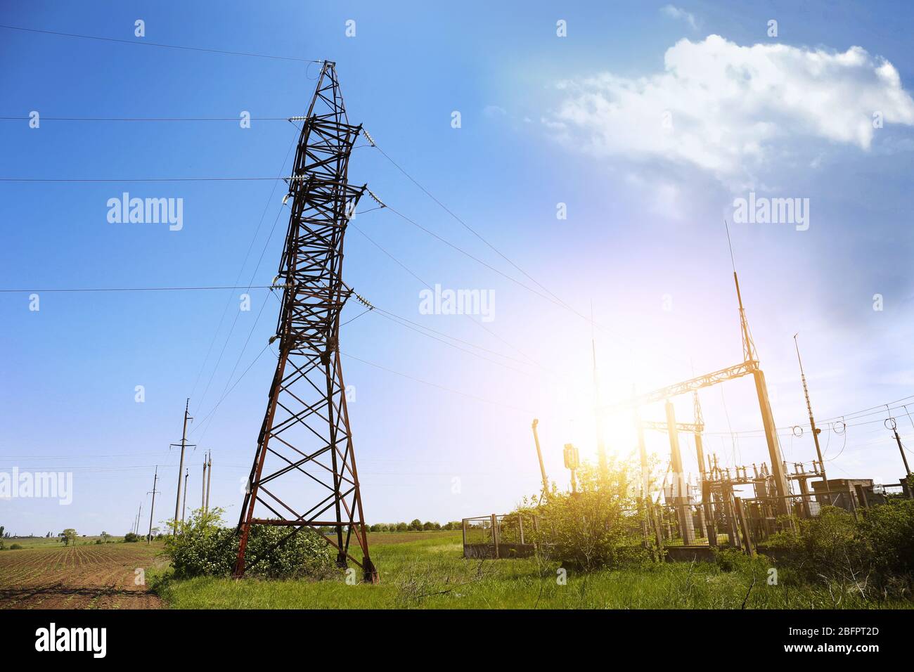 Field with electrical transmission tower and substation Stock Photo - Alamy