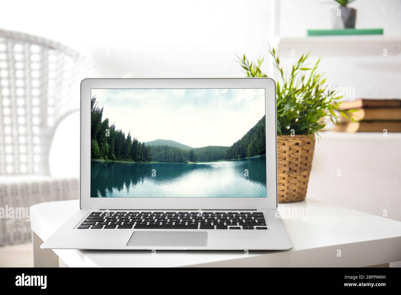 Workplace with laptop and wallpaper of landscape on screen Stock Photo ...