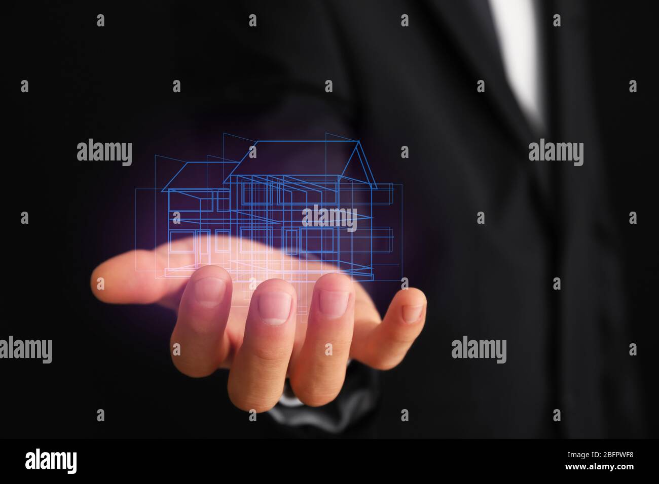 Real estate agent holding projection of house on dark background Stock ...