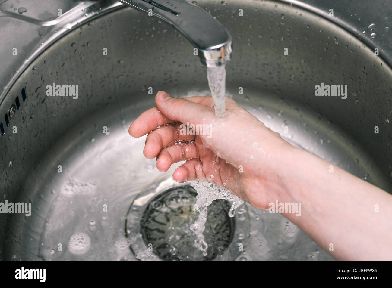 Man washes his hands under running water. Hand under the tap with soapy ...