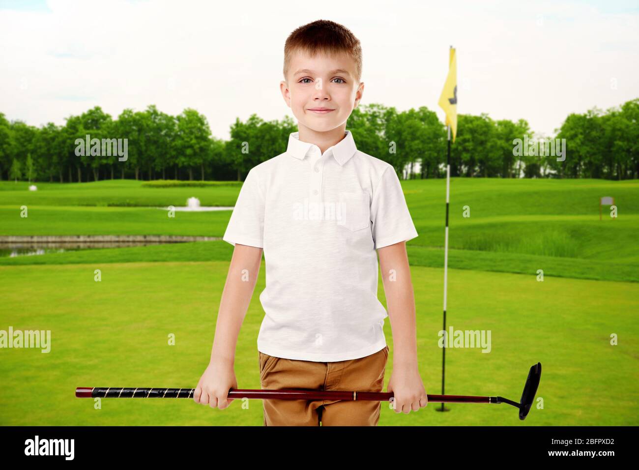 Little boy with golf club on course Stock Photo - Alamy