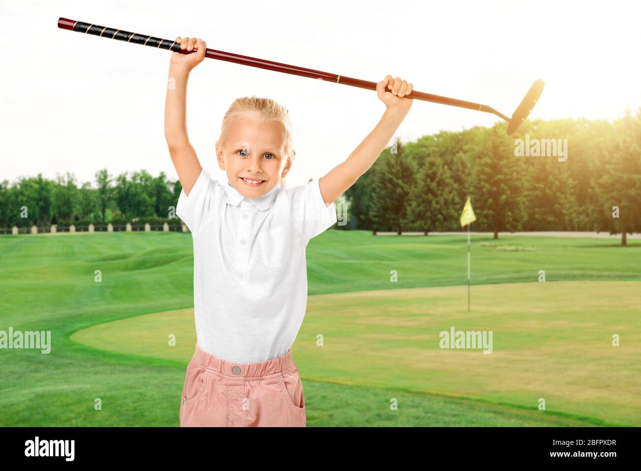 Little girl playing golf on course Stock Photo - Alamy