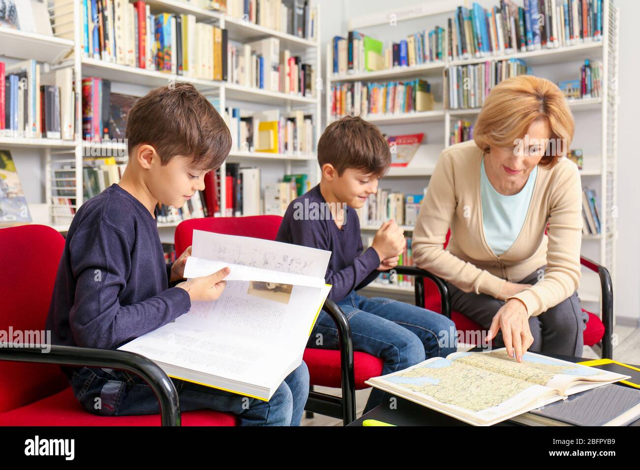 Teacher and children at school library Stock Photo - Alamy