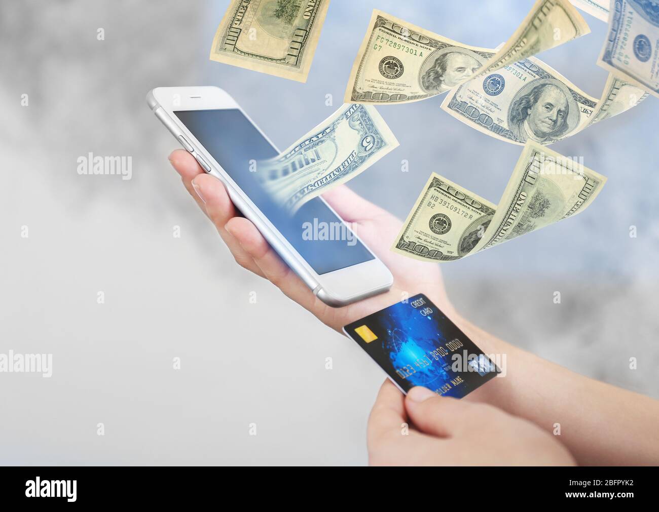Money flying out of smartphone while woman using it on blurred ...