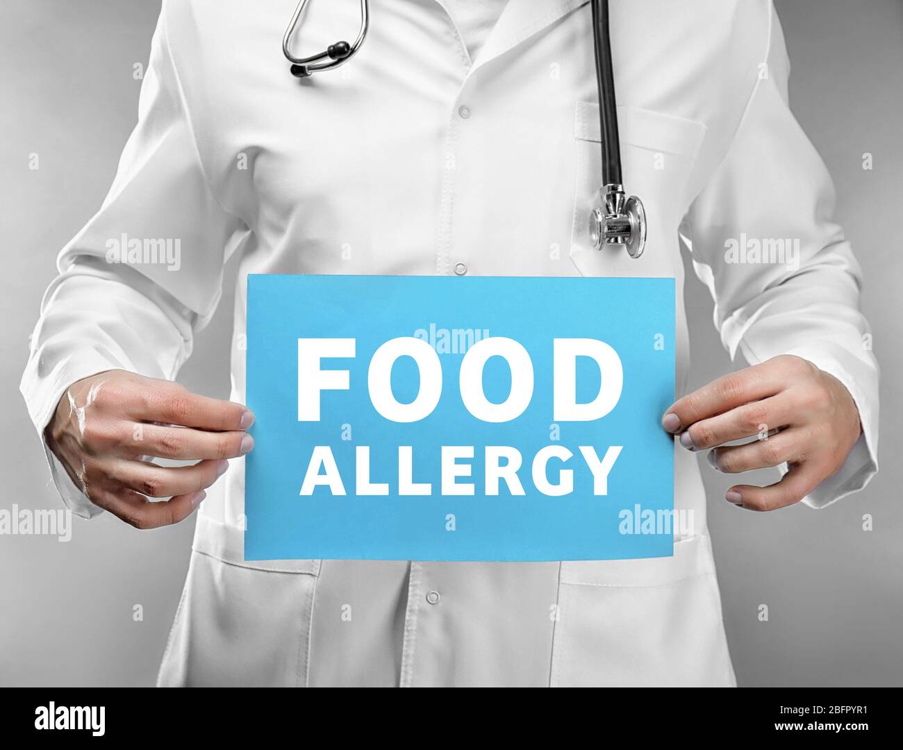 Doctor holding paper with text FOOD ALLERGY on grey background Stock ...