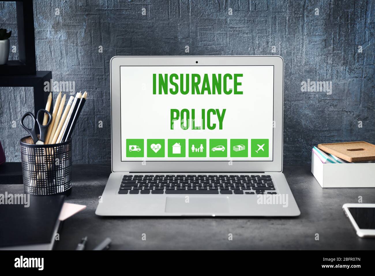 Modern workplace with laptop and text INSURANCE POLICE on screen Stock ...