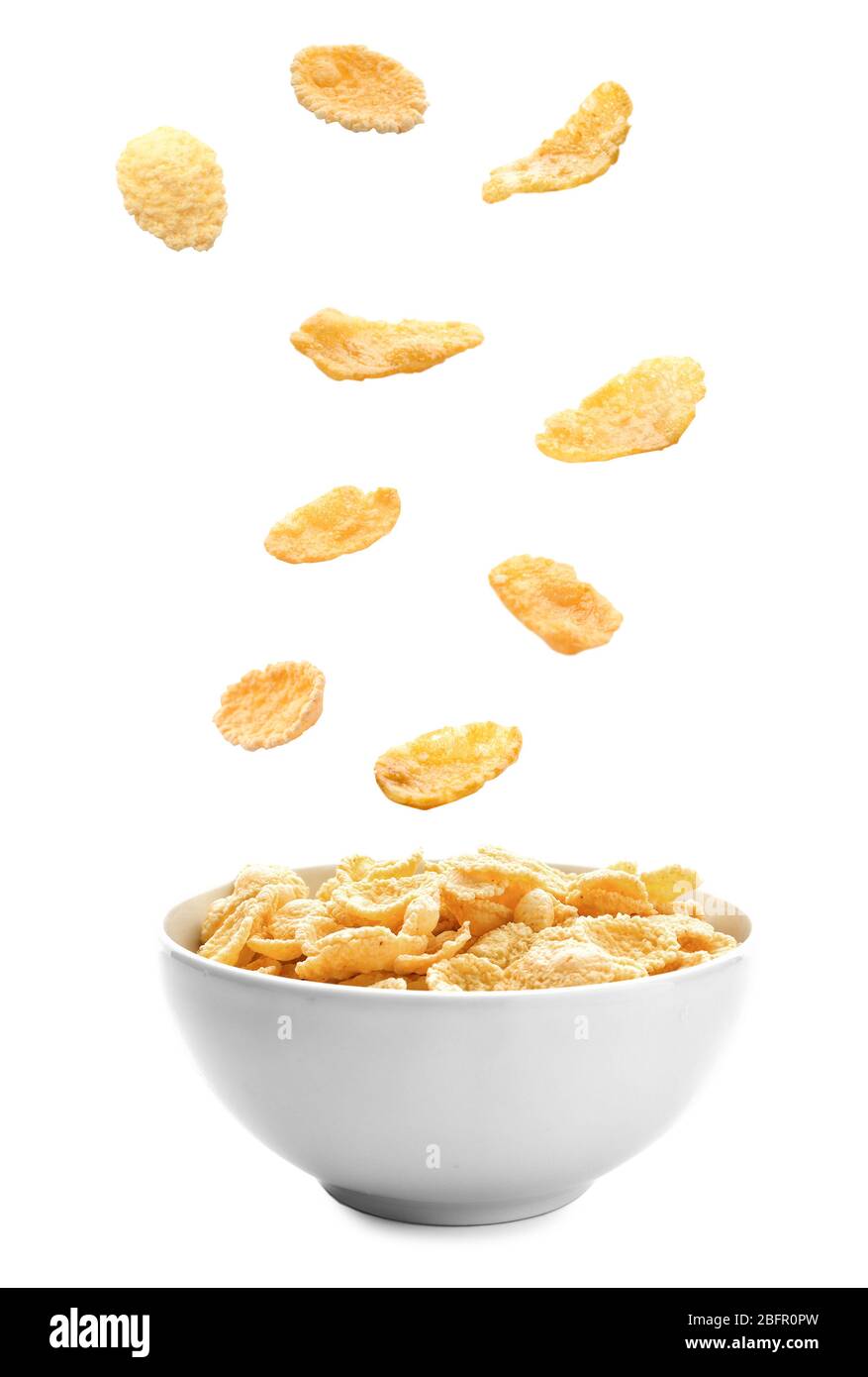 Corn flakes falling into bowl on white background Stock Photo - Alamy